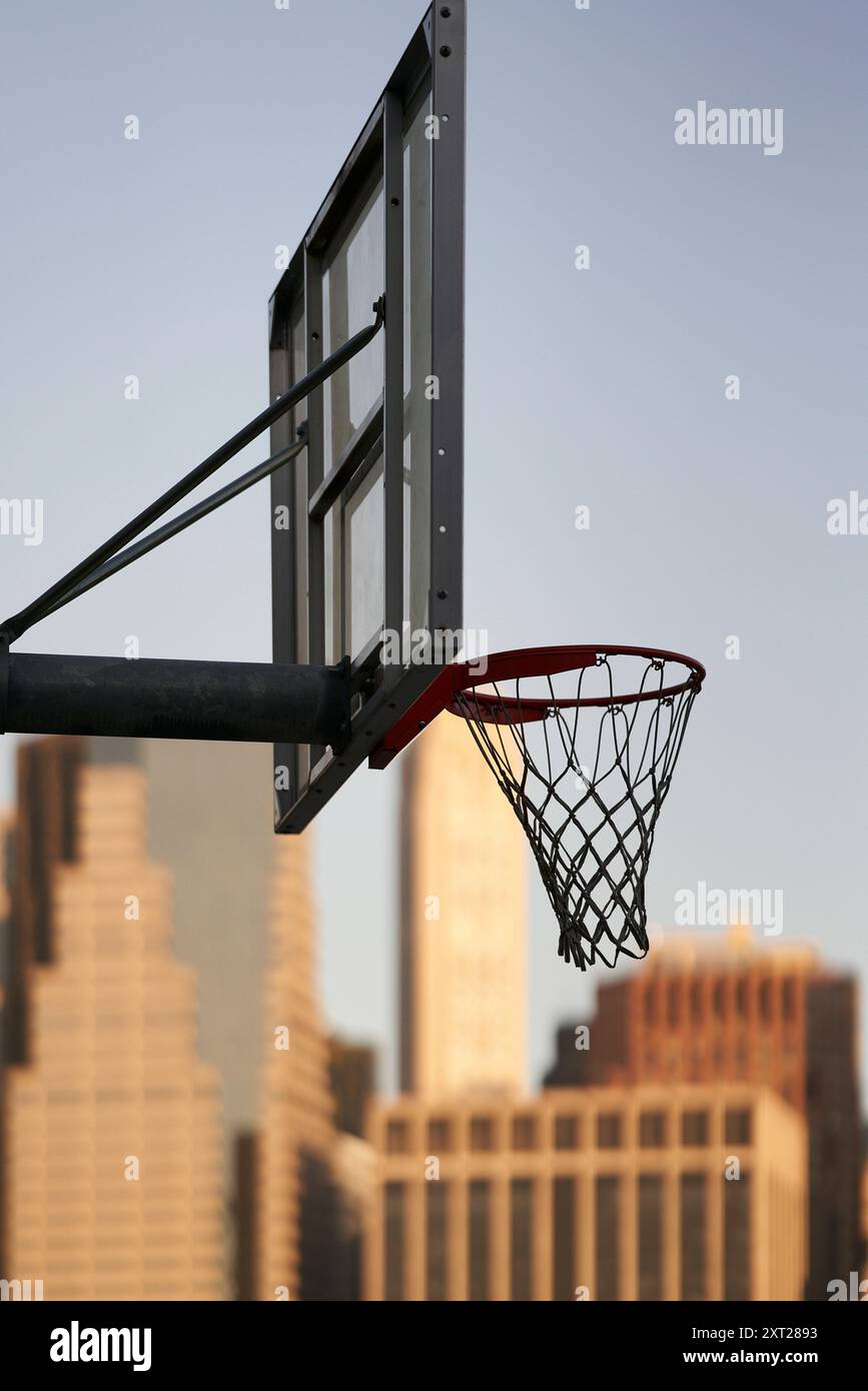 Outdoor basketball hoop with a clear backboard against a backdrop of ...