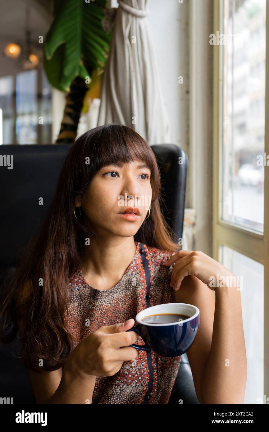 Young asian woman drinking hot coffee released Stock Photo - Alamy