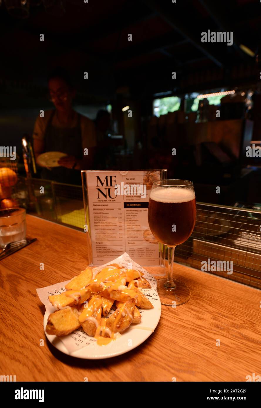 A plate of Patatas Bravas with a glass of draft beer. Mercat de Santa ...