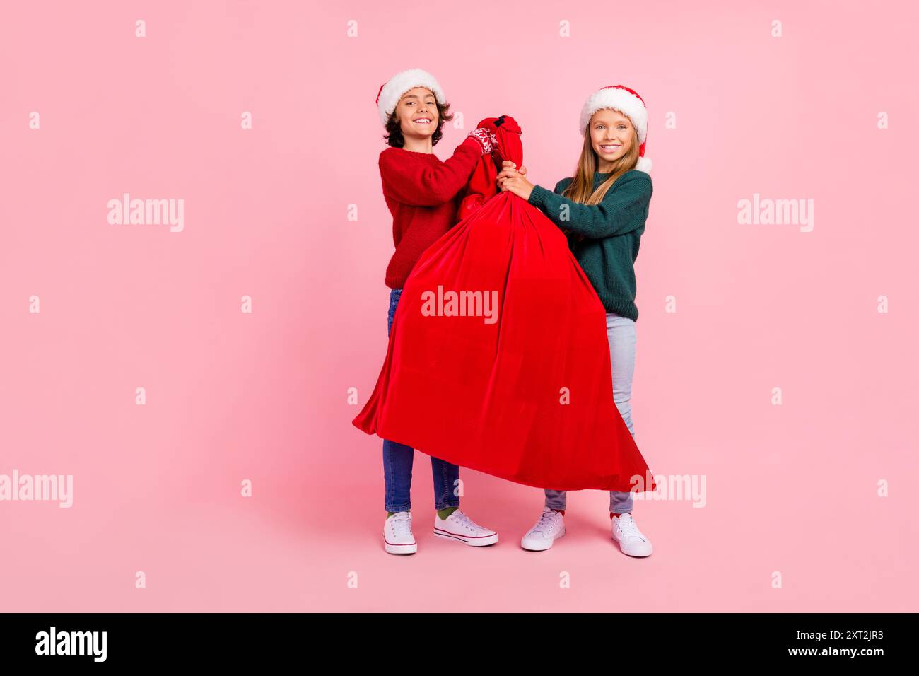 Photo of two people kids hold big red santa claus sack isolated pastel ...