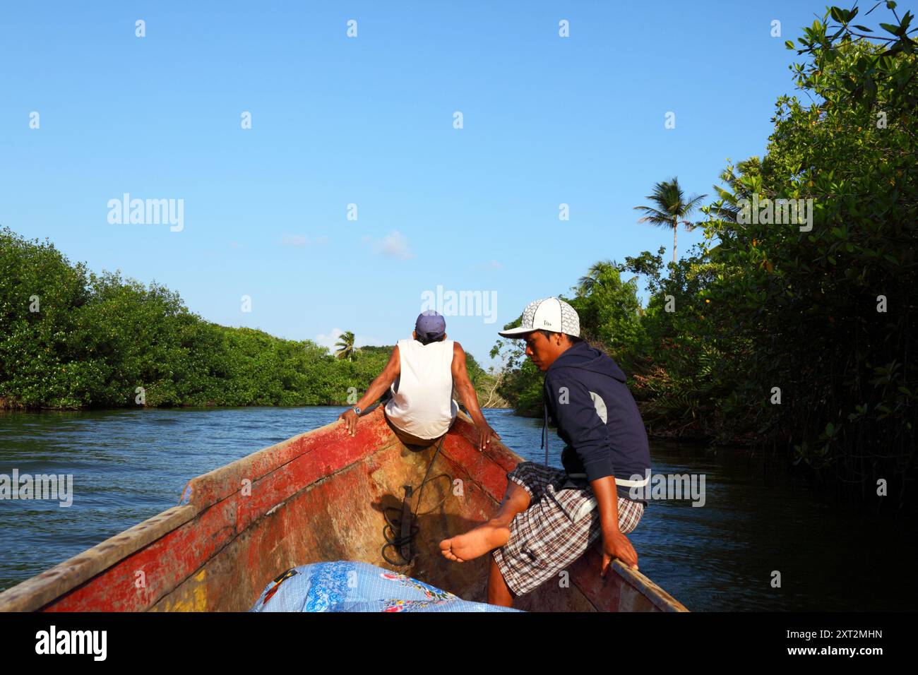 Kuna indigenous boys sitting on prow of a traditional dugout wooden ...