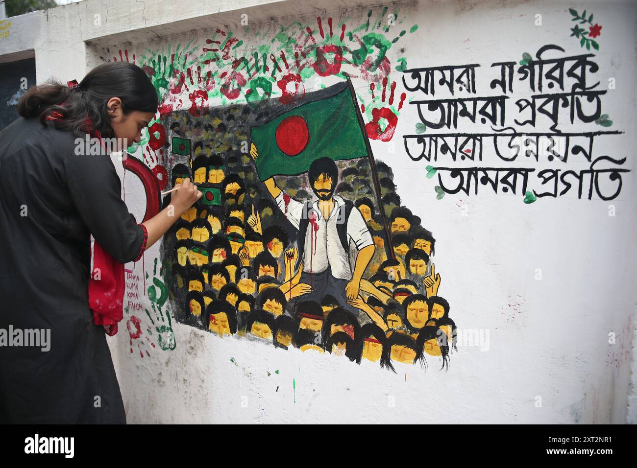 A student paints a new graffiti on a street wall at Dhaka University ...