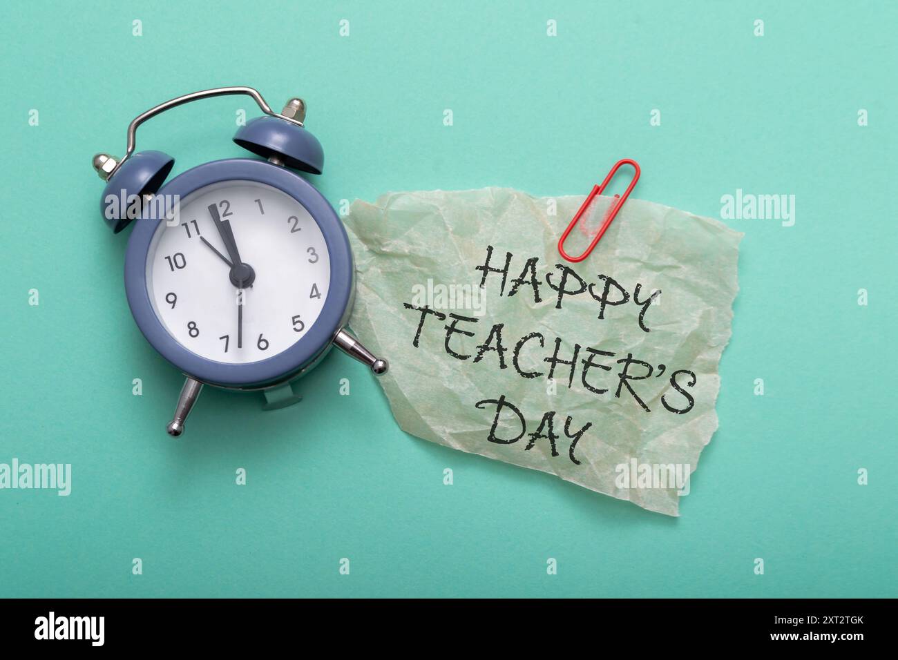 A clock is on a green background with a piece of paper that says Happy ...