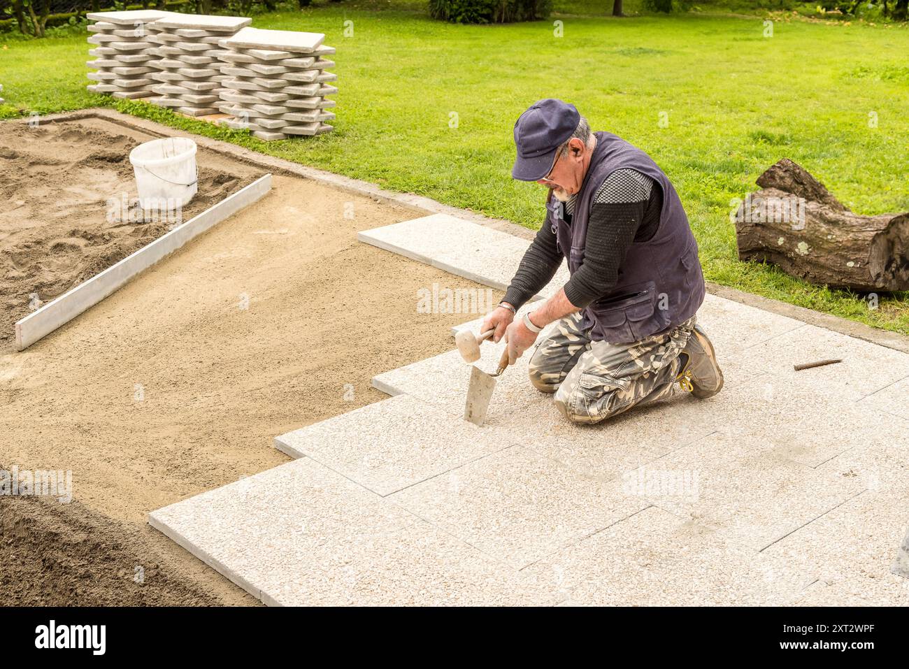 A worker is placing the concrete slabs floor. Groundwork and exterior ...