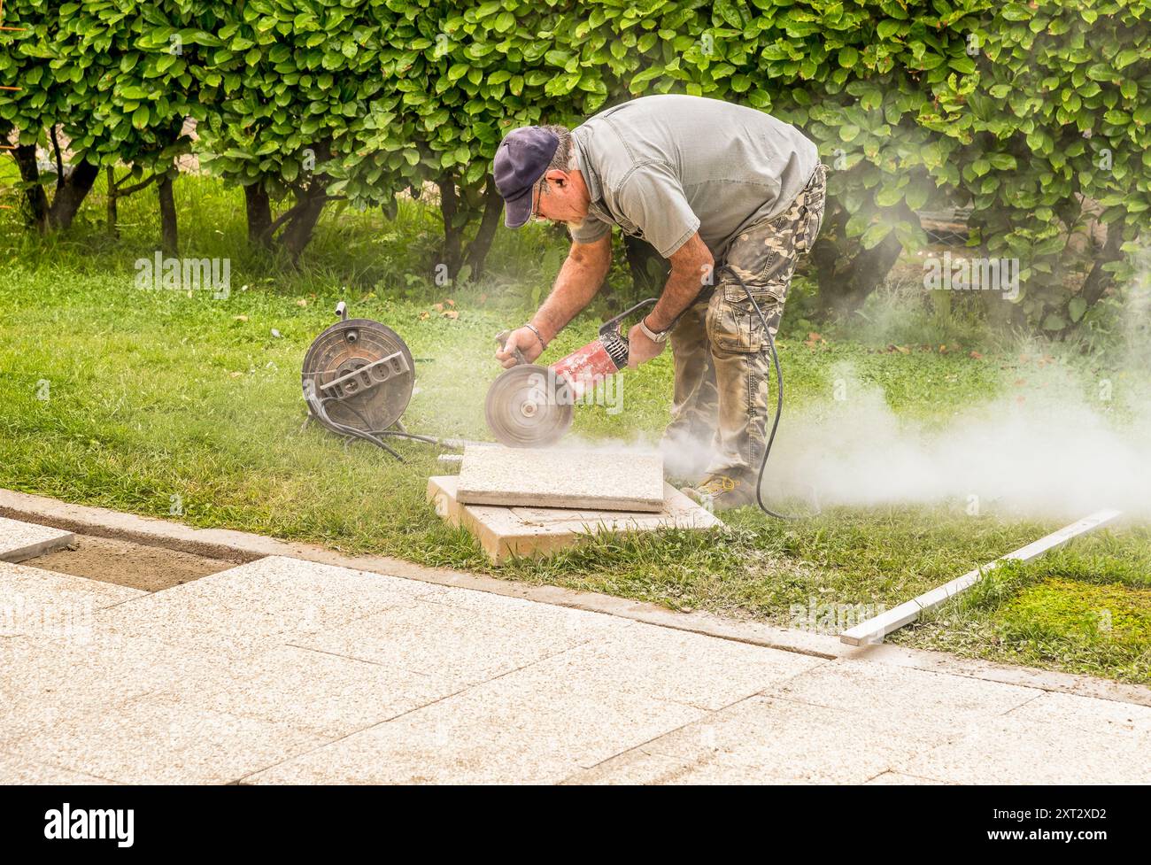Worker cutting concrete slabs for floor with circular electric saw ...