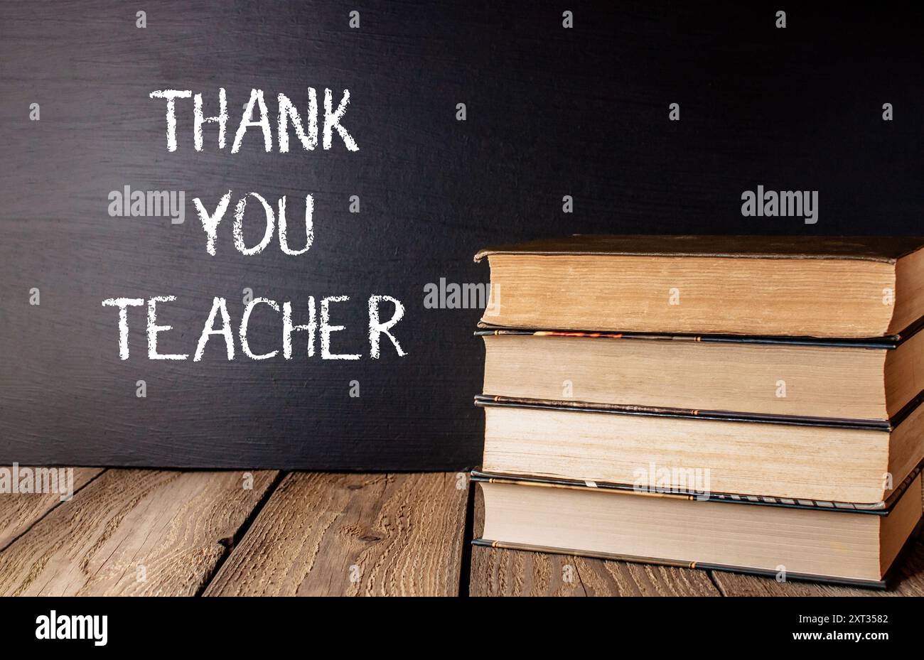 A stack of books with a chalkboard underneath that says Thank You ...
