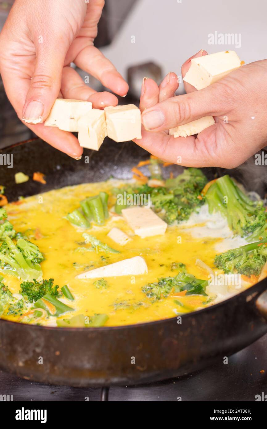 Add processed cheese to puree soup. Cook food Stock Photo - Alamy