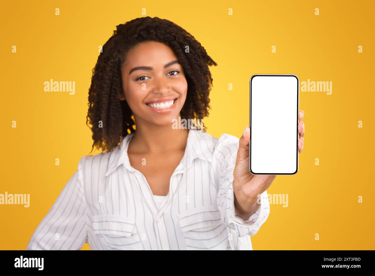 Happy black girl showing white mobile screen Stock Photo - Alamy