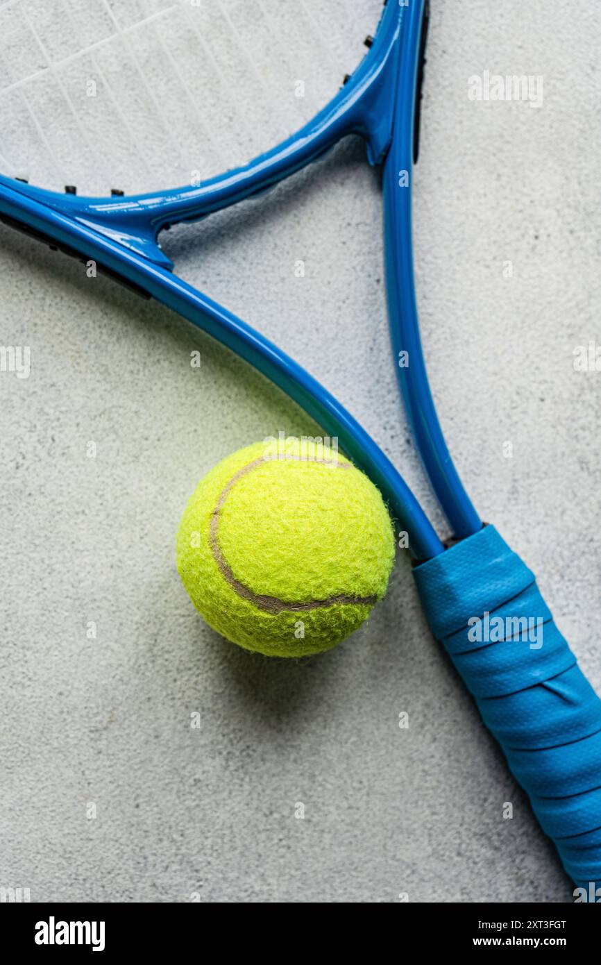 A detailed close-up image showing a blue tennis racket with a wrapped ...