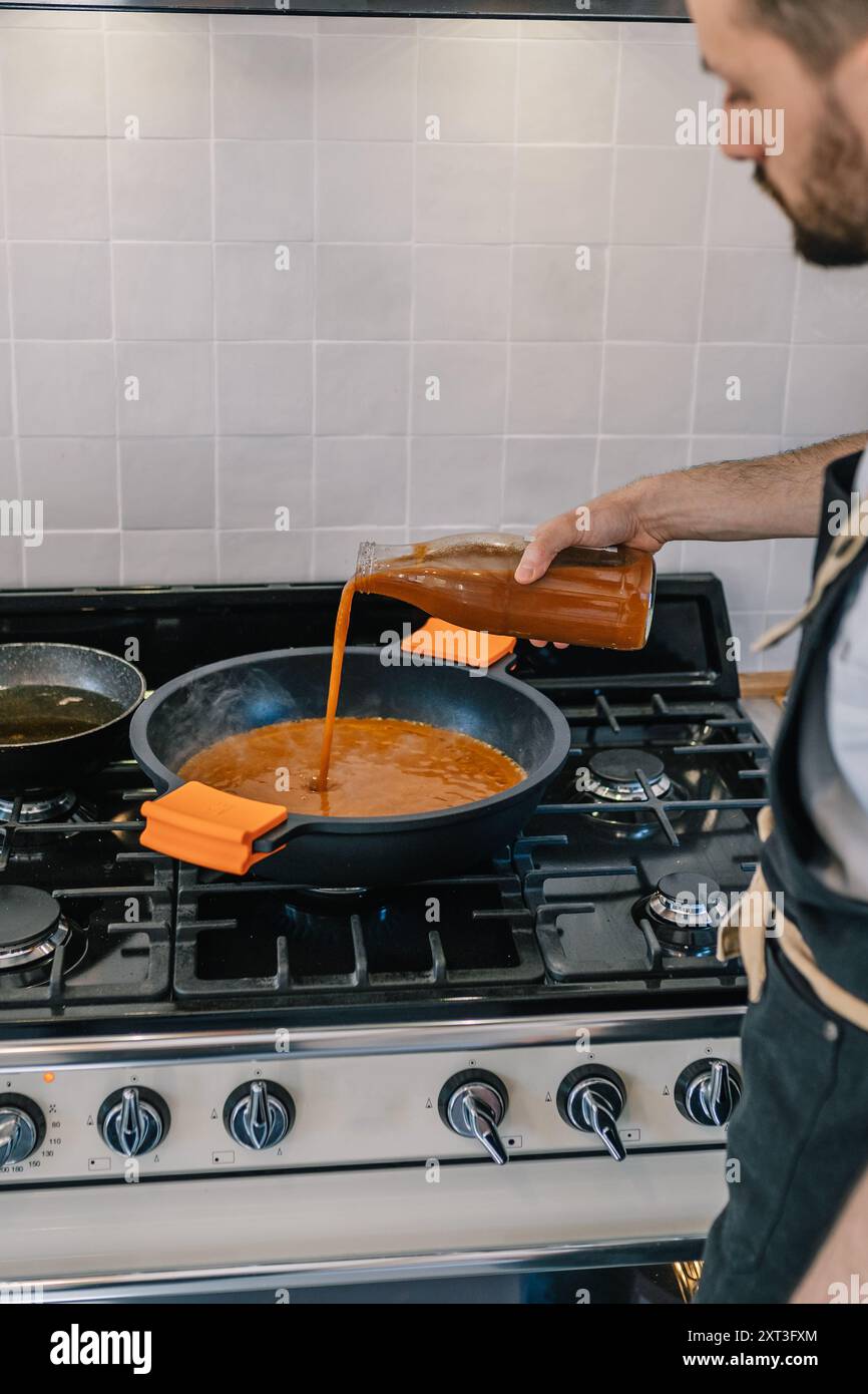 A cropped unrecognizable chef, dressed in a casual apron, expertly ...