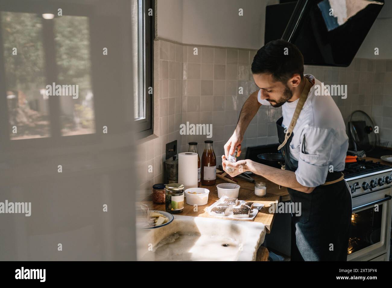 A Private chef wearing a white chef's shirt and apron well-lit modern ...