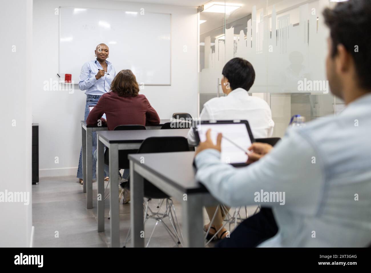 In an illuminated classroom, an African American woman leads a ...