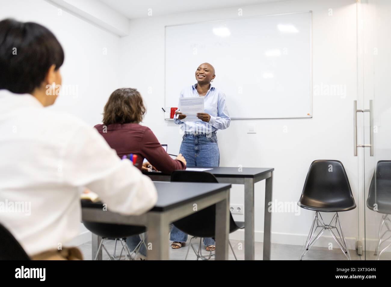 An enthusiastic African American woman stands, leading a discussion in ...