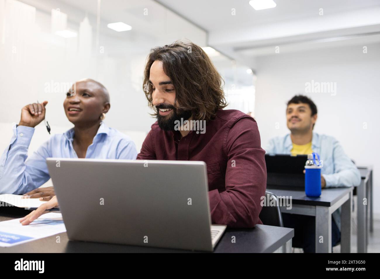 A diverse group of adults engaged in a collaborative learning session ...