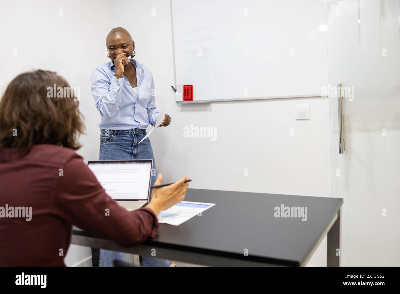 A female instructor discussing with a student in a well-lit modern ...