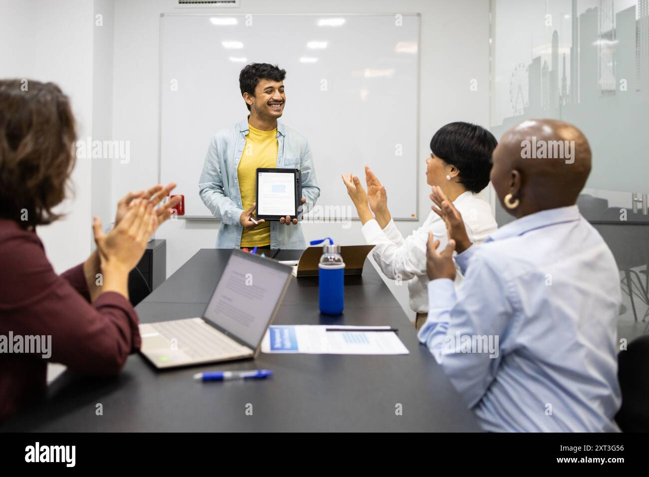 In a modern classroom, a young man receives recognition from the ...