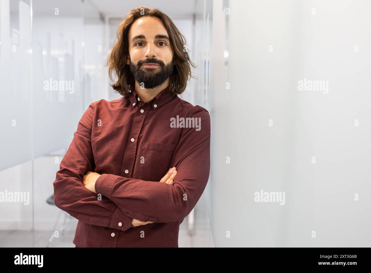 A confident and approachable male teacher stands in a bright, modern ...