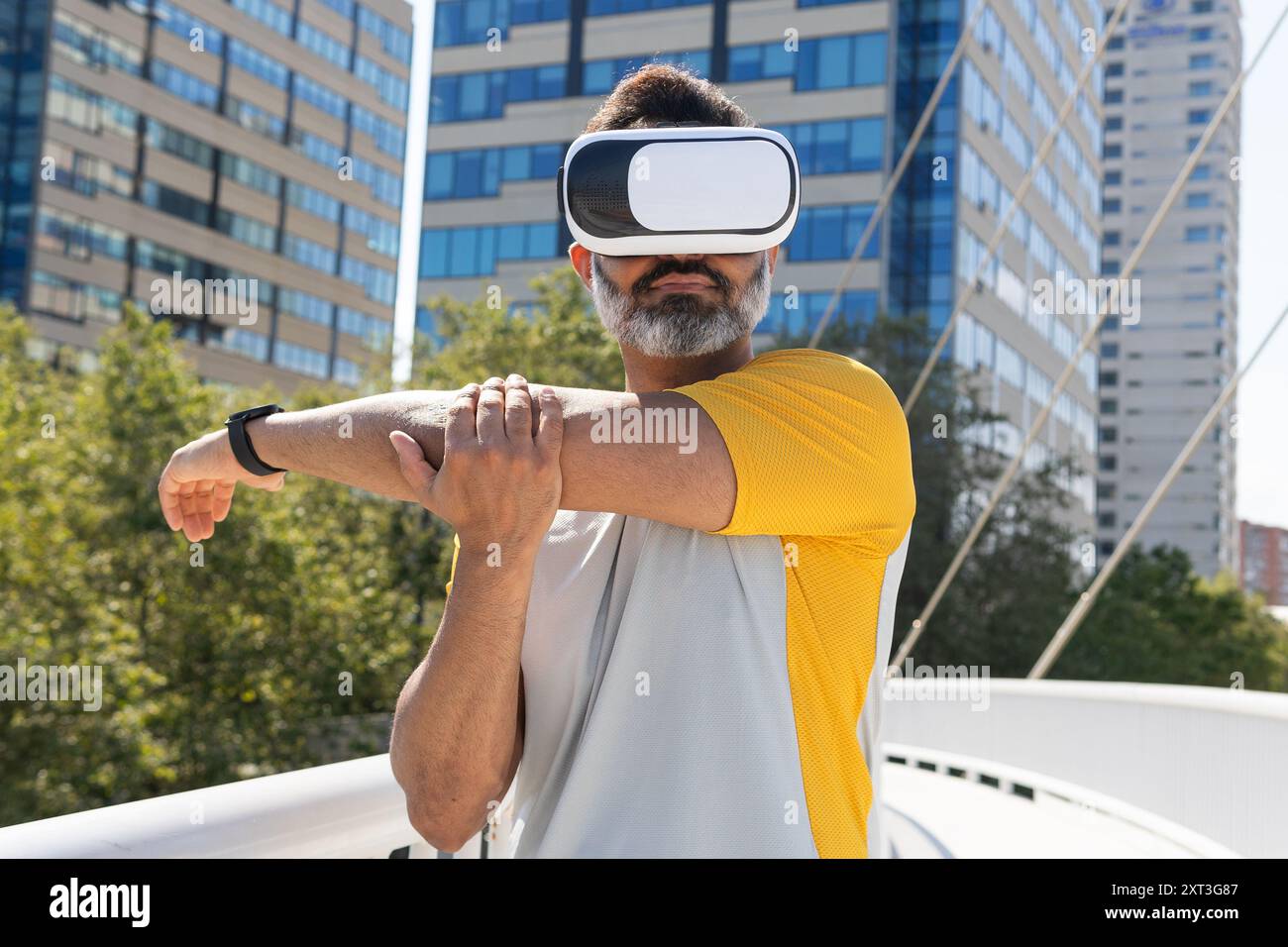 Indian man in sports attire uses a VR headset and smartwatch for an ...