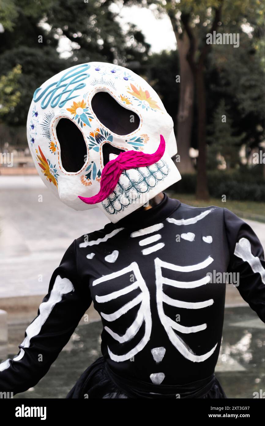 A person wears a Catrin mask and skeleton-themed bodysuit, celebrating ...
