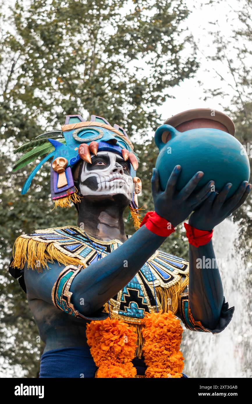 A person in a vibrant Catrin costume with skull makeup and a large ...