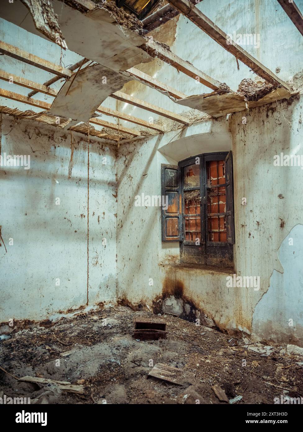 An interior view of an abandoned room showcasing deteriorating walls, a ...
