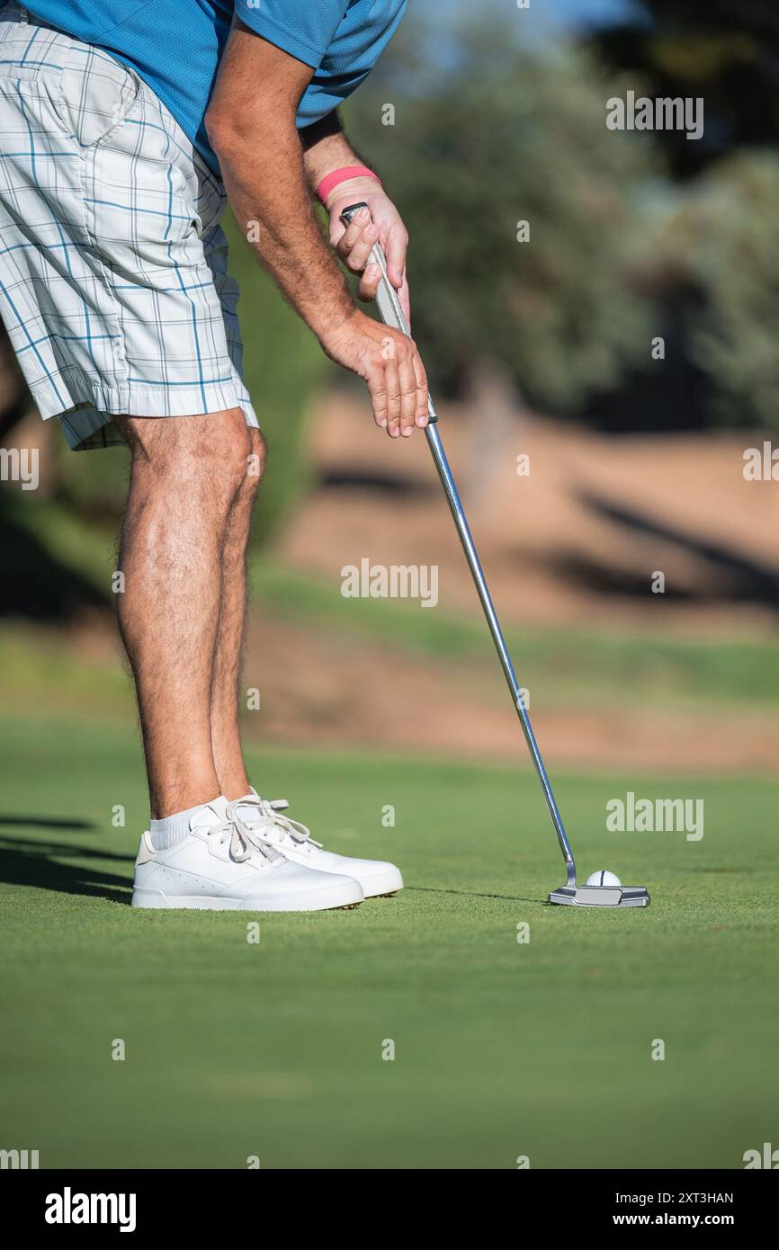 Side view of unrecognizable middle-aged man playing golf, focusing on ...