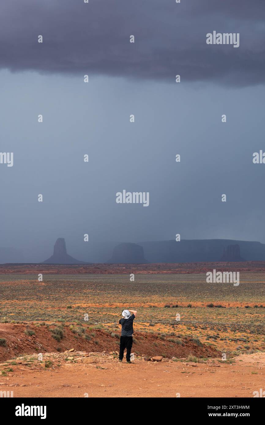 A solitary figure stands in the vast expanse of Monument Valley ...
