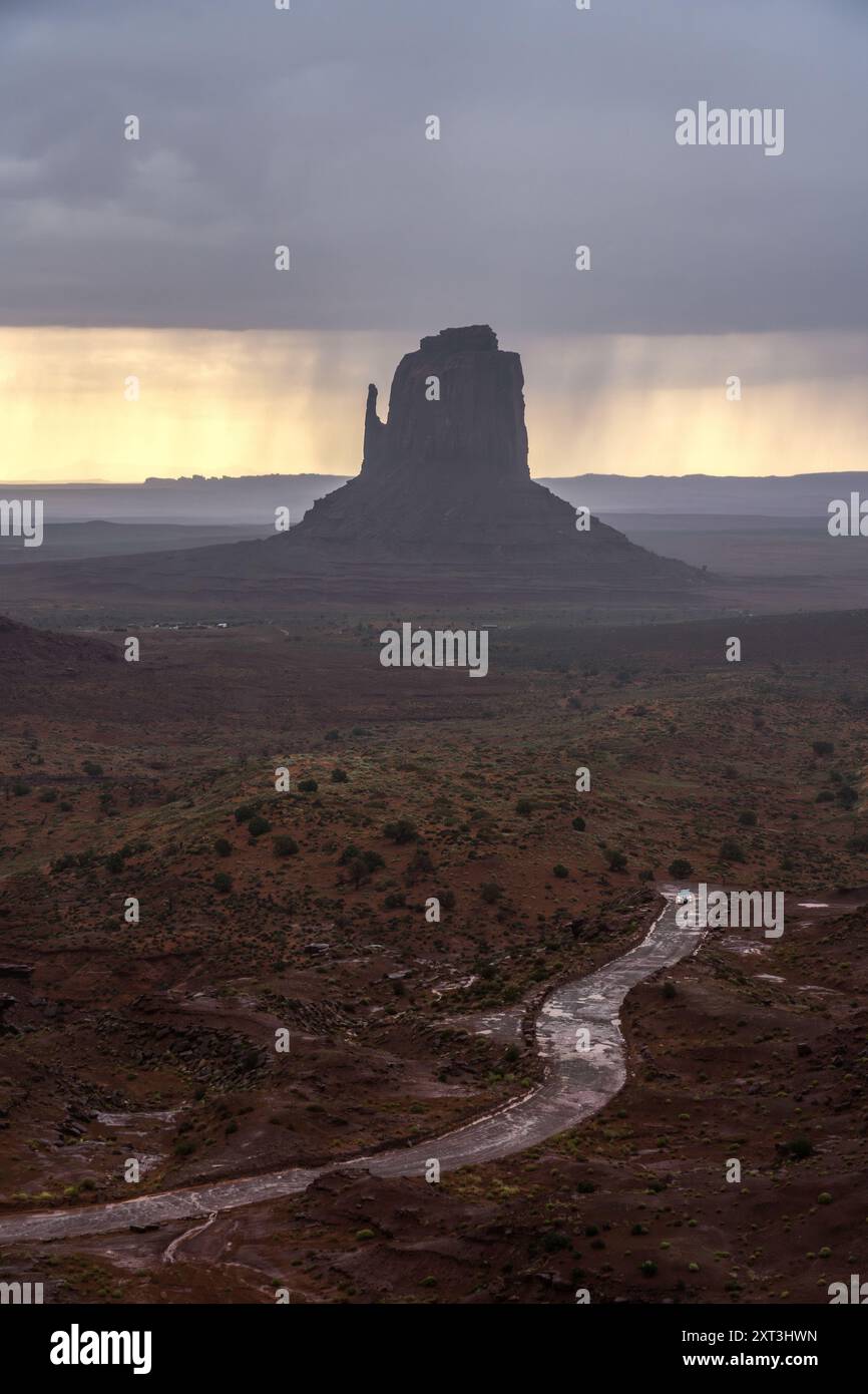 A moody view of Monument Valley as a storm brings rain, casting ...