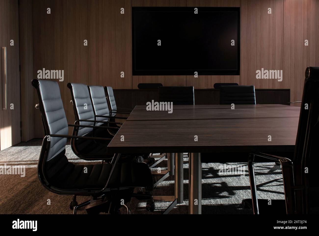 Modern conference room featuring a sleek wooden table, ergonomic chairs ...