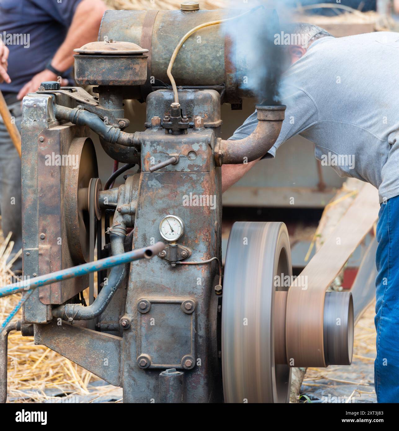 A person operates a vintage mechanical device used in the traditional ...