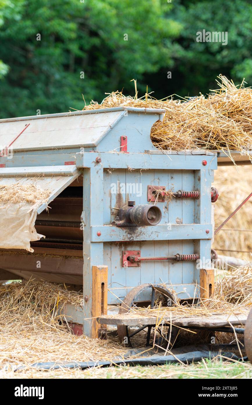 A close-up image of a vintage wheat thresher, demonstrating the ...