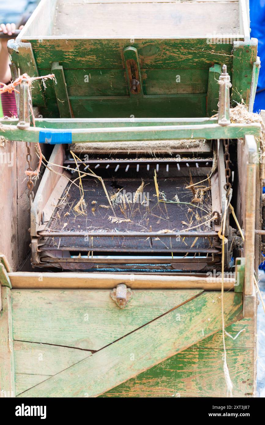 Close-up of a vintage threshing machine processing wheat, showcasing ...