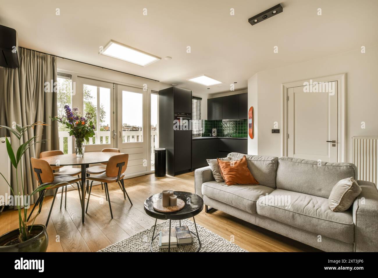 A contemporary living room seamlessly integrates with a stylish kitchen ...