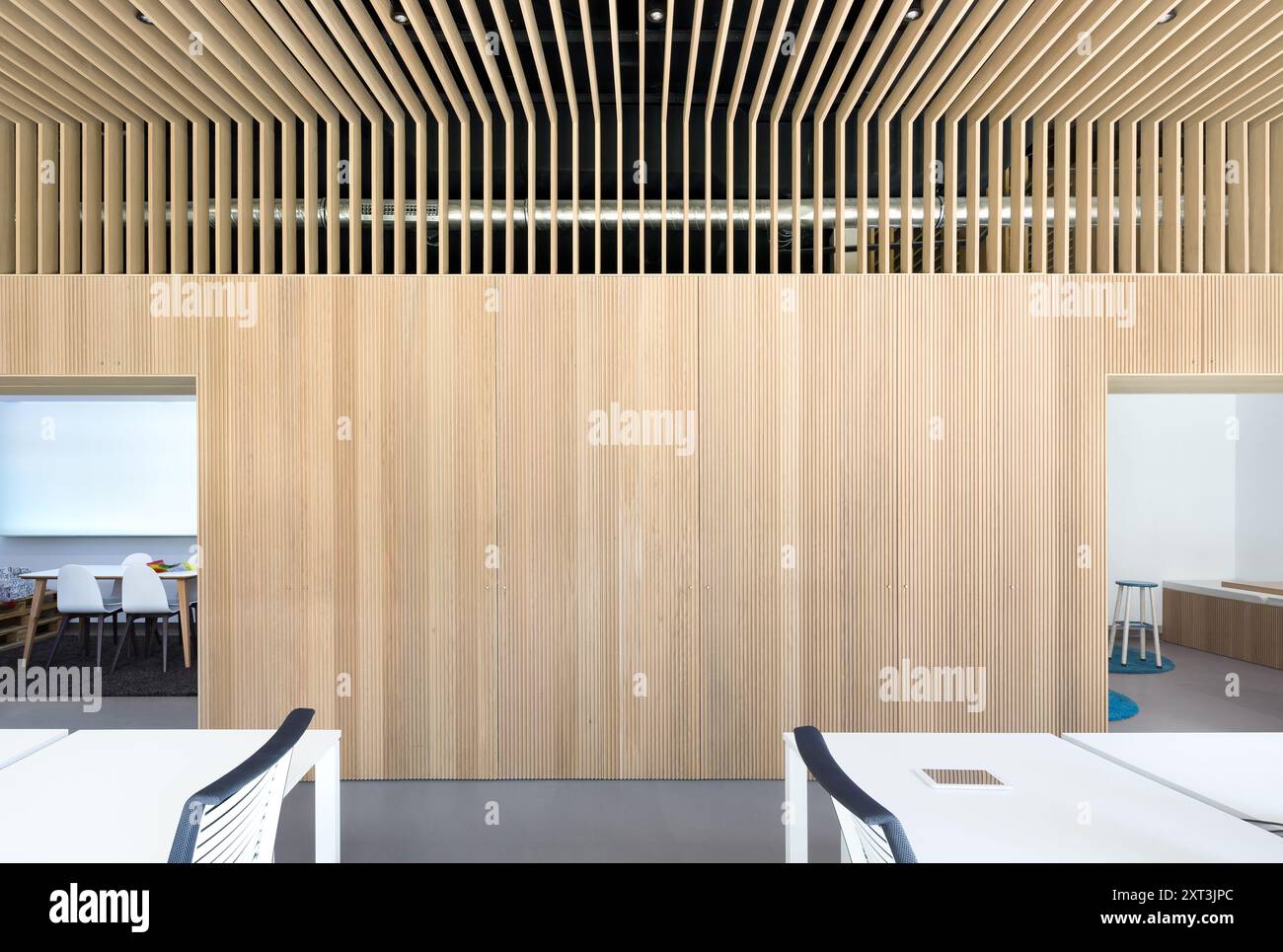 A contemporary office featuring sleek wooden slats on the ceiling and ...
