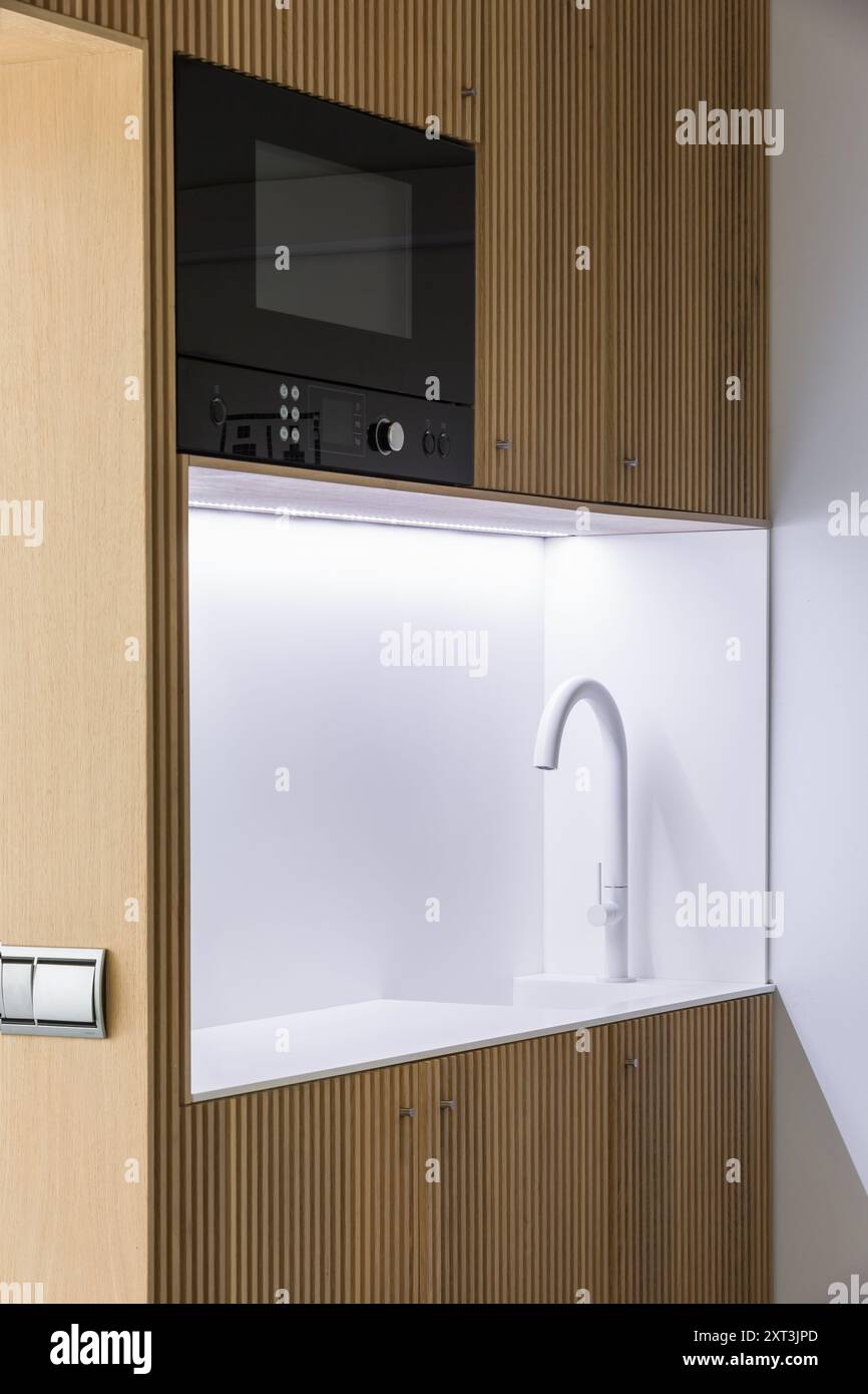Minimalist kitchen design featuring a sleek white sink and a built-in ...