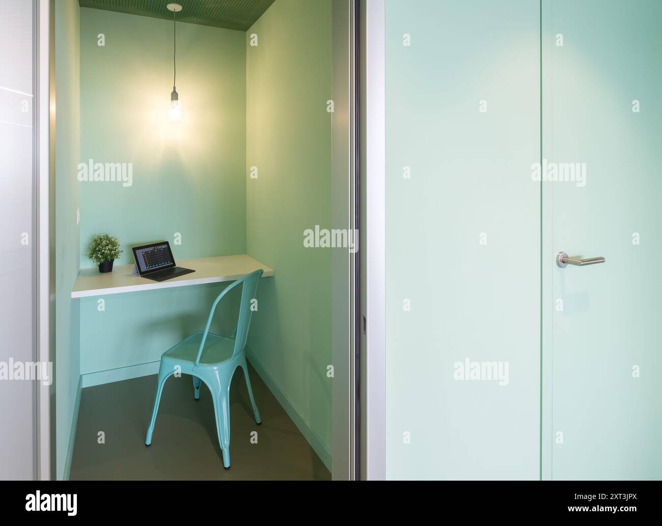 A neatly organized small home office space features a sea green color ...