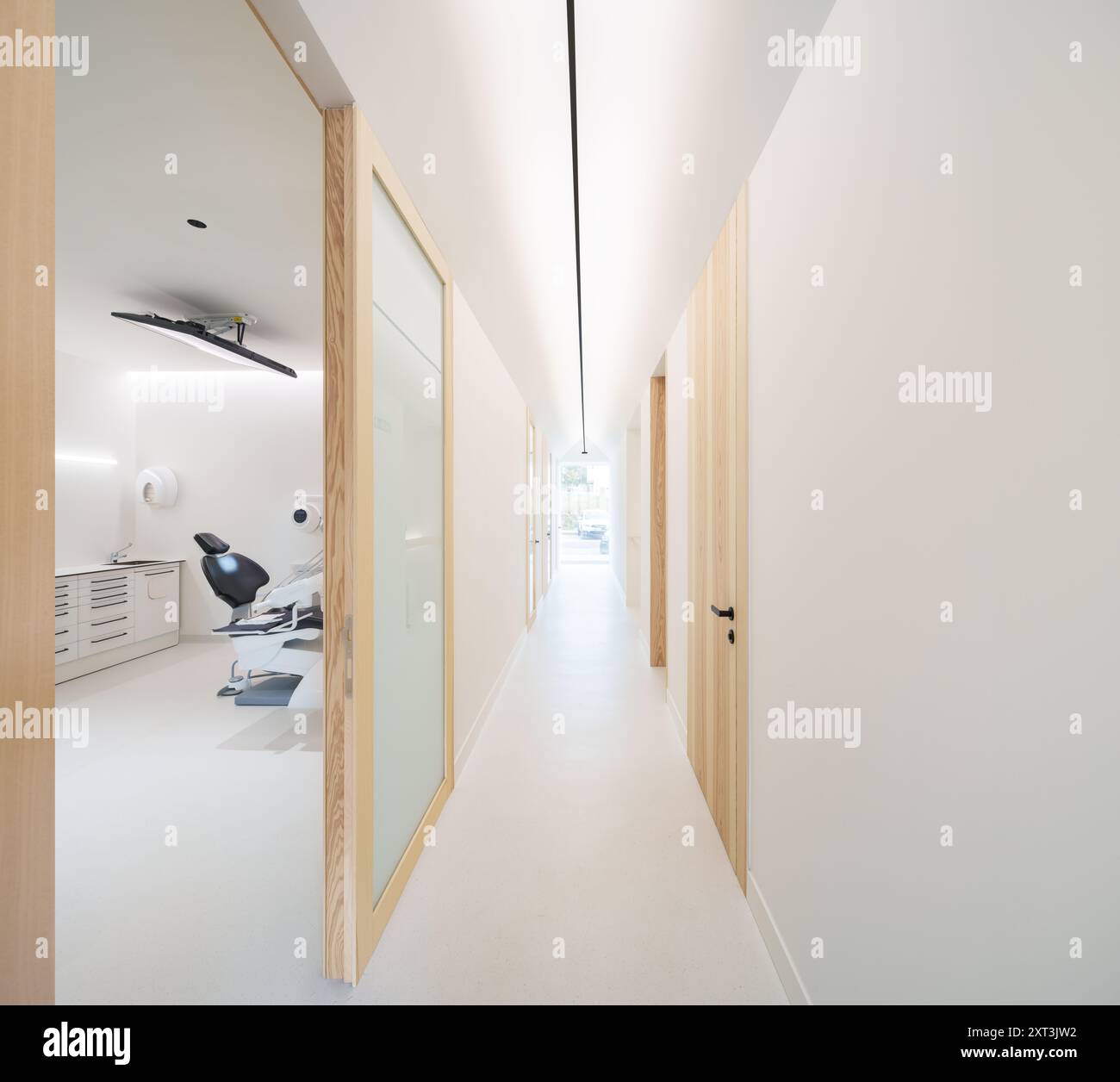 A contemporary, well-appointed dental clinic featuring a wide hallway ...