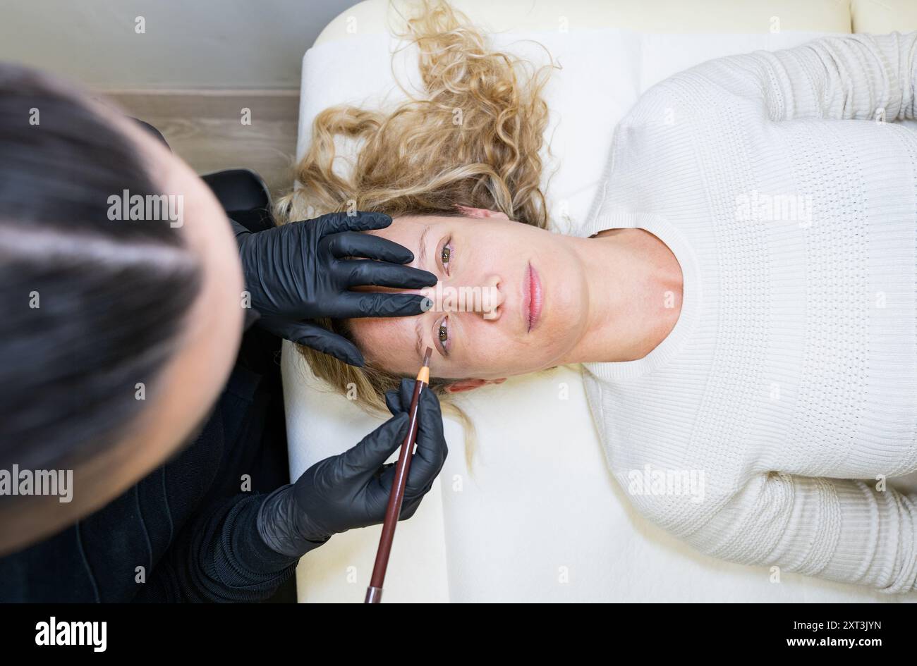 A beautician outlines the microblading process to a client, sketches ...