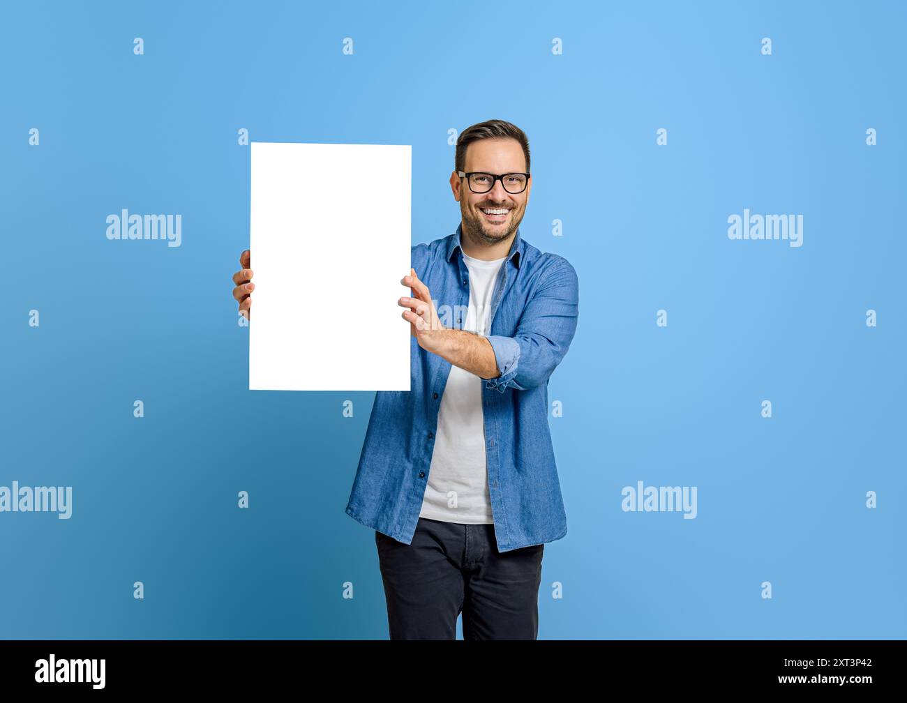 Portrait of happy male manager showing blank white poster for marketing ...