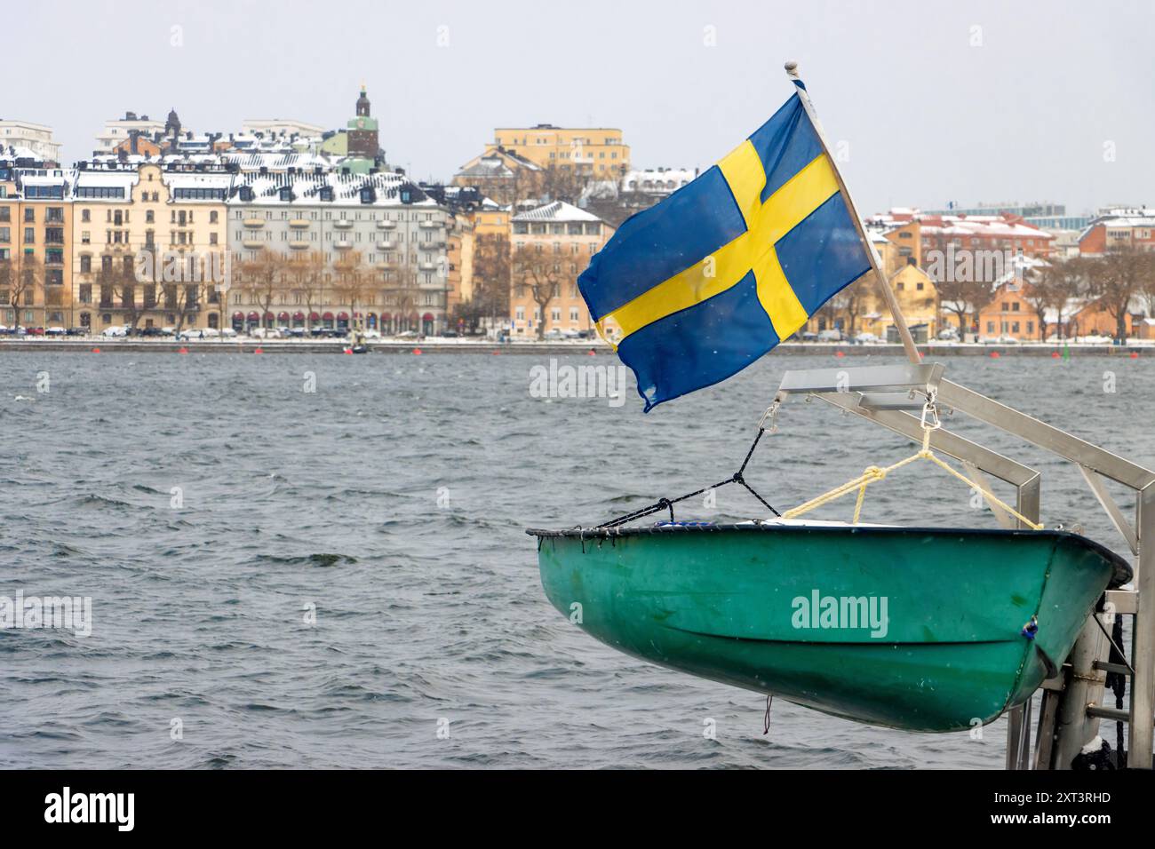 The Swedish flag flies above a ship moored on the shore in central ...