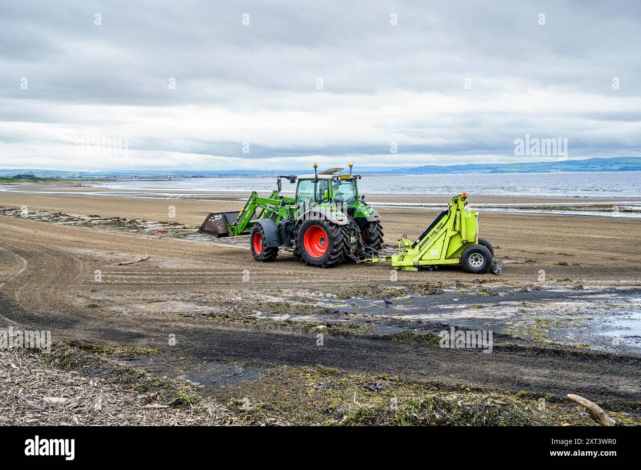 Debris being cleared with a Fendt tractor towing a Barber Surf Rake on ...