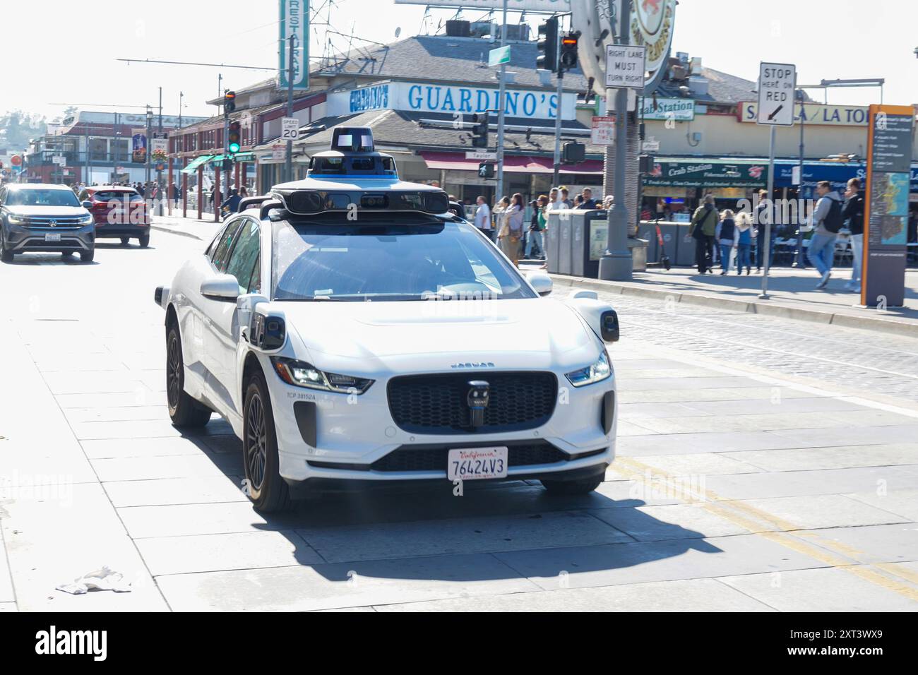 A Waymo autonomous car cruises down the street on its way to pick up a ...