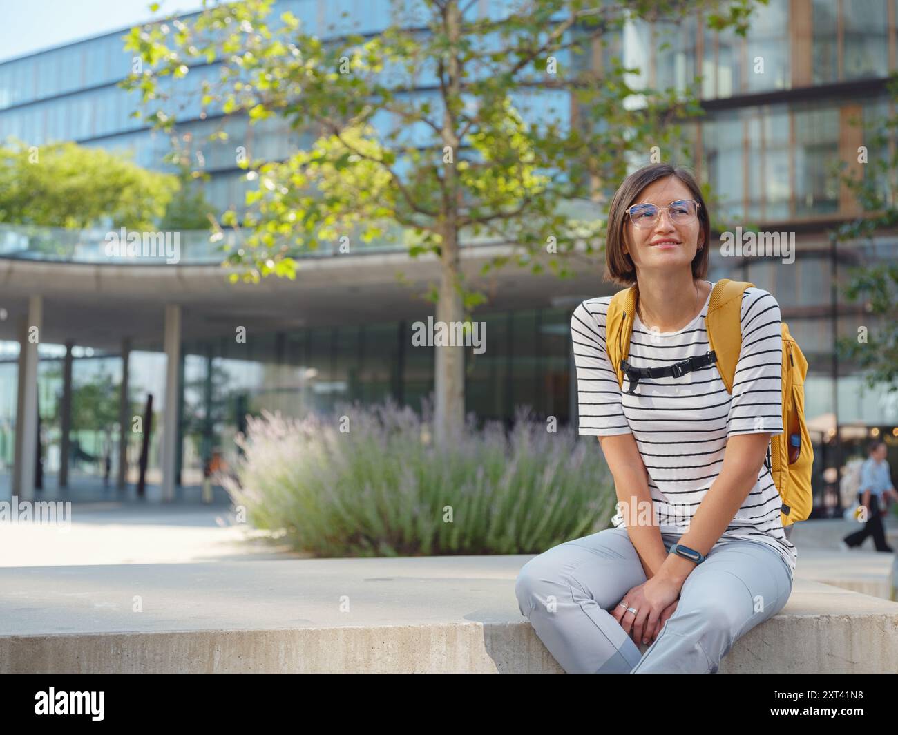 Asian woman with yellow backpack over background of modern urban ...