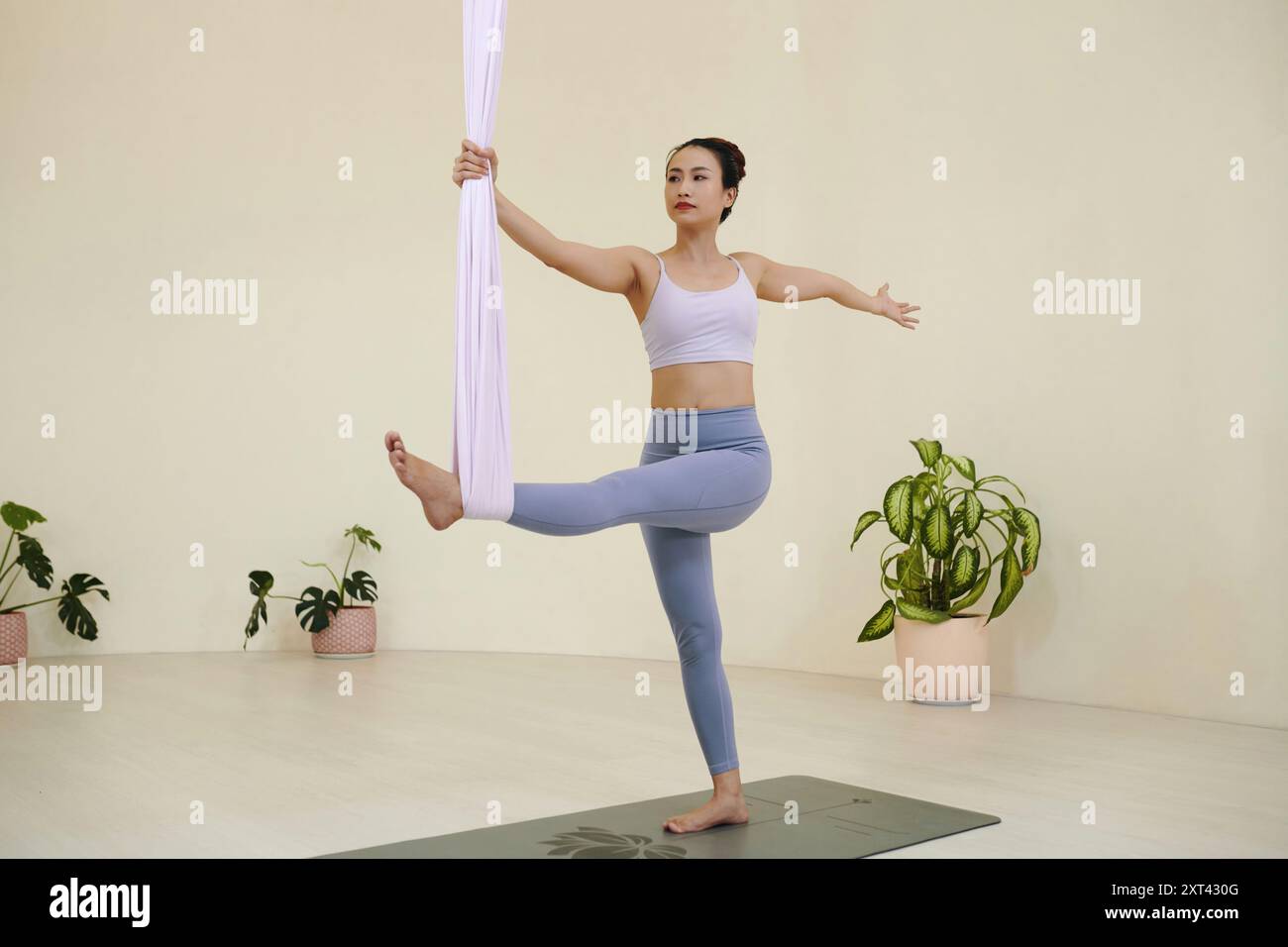 Performing Aerial Yoga with Graceful Pose on Mat Stock Photo - Alamy
