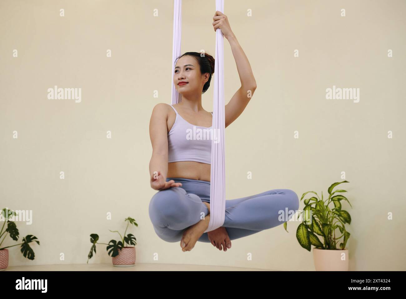 Practicing Aerial Yoga Poses with Calm Expression Stock Photo - Alamy