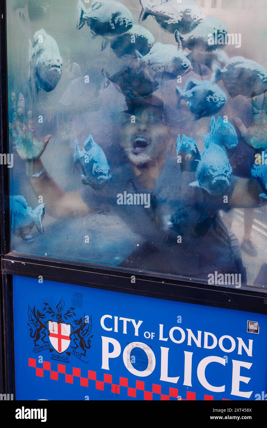 A Banksy fan poses inside a police sentry box painted with piranhas by ...