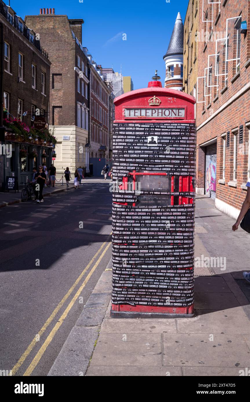 A sealed up and unusable red telephone box in Soho with "New World ...