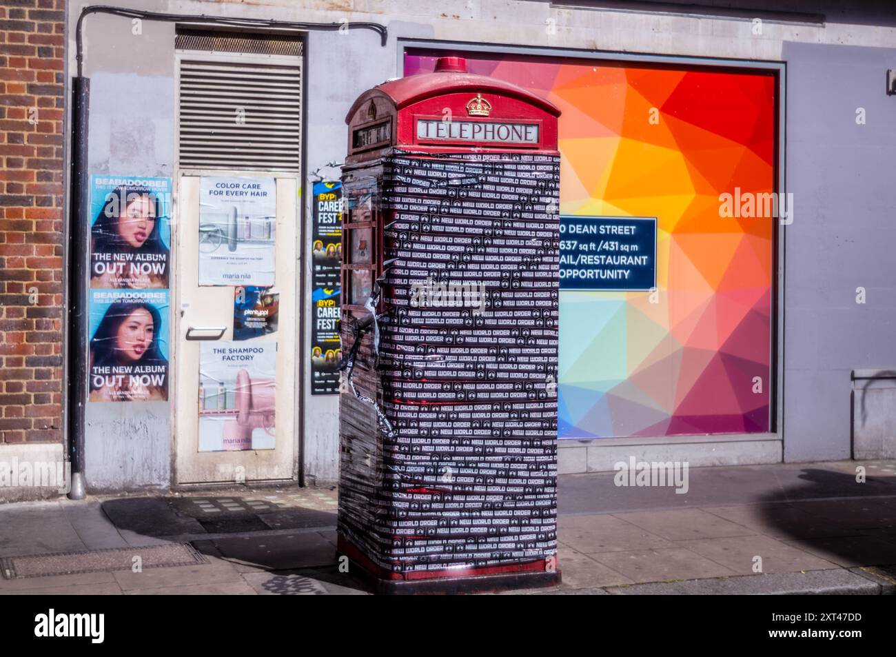 A sealed up and unusable red telephone box in Soho with "New World ...