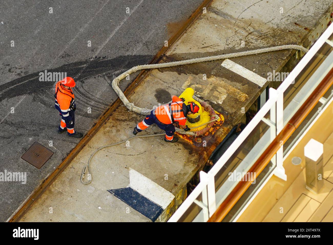 The process of mooring a large cruise ship with a rope at the harbor ...