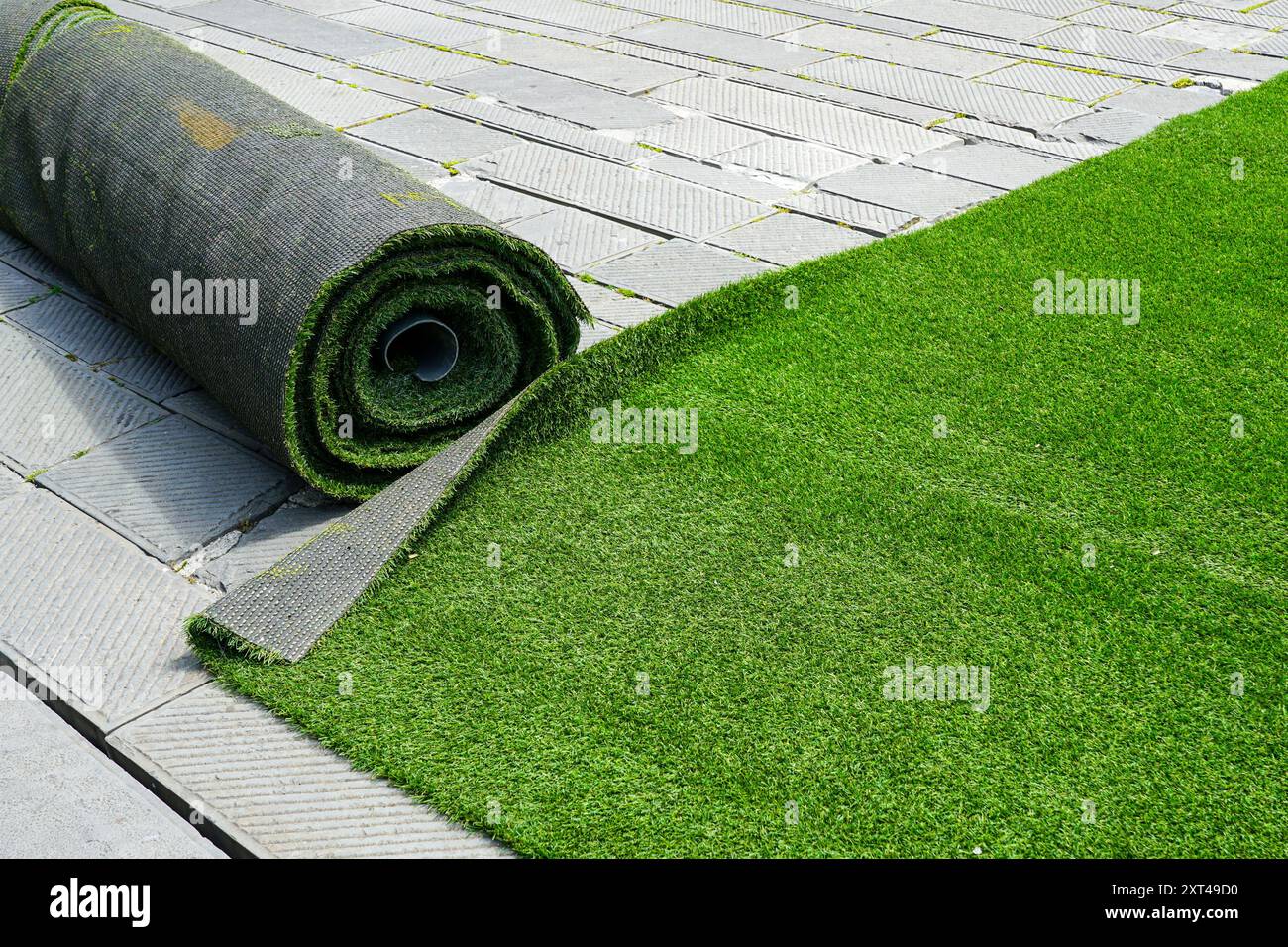 Preparing artificial green grass carpet rolls for outdoor event ...